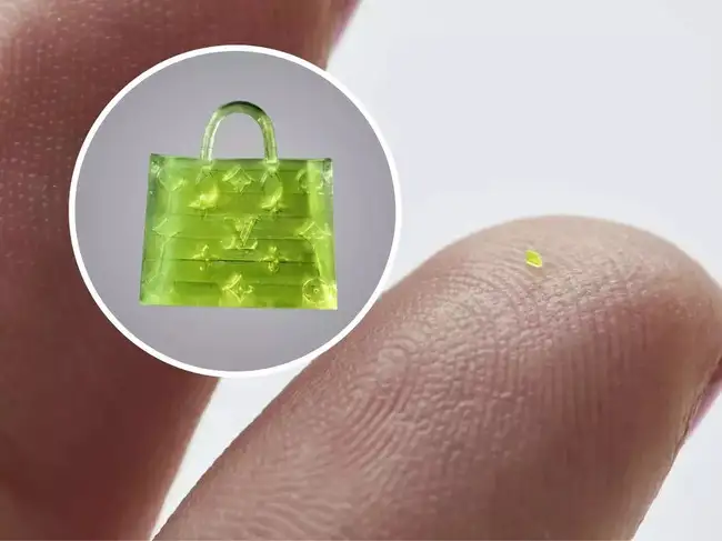 This fluorescent green speck on the finger is a Microscopic Handbag, a ...