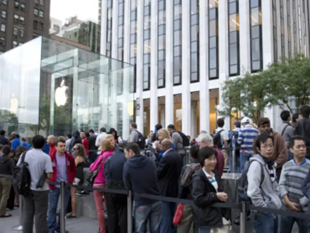Apple Store employees create a tunnel for customers as they are allowed ...