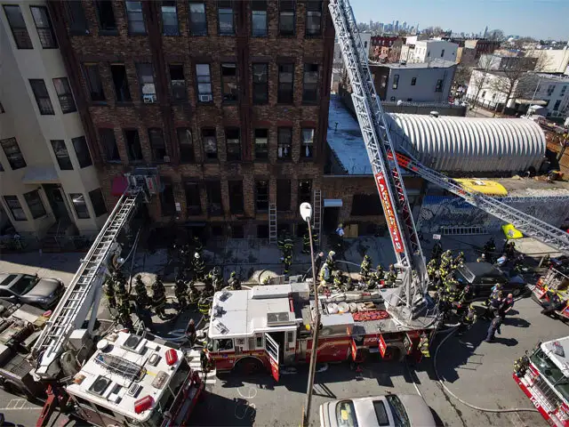 Firefighters fight to contain a fire that broke out in a residential ...