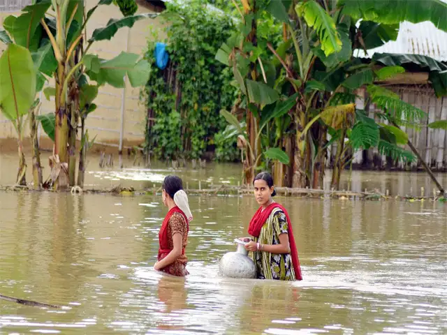 Girls walk in flood affected area - Floods wreak havoc across India ...