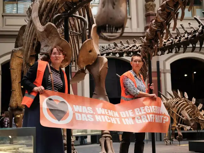 German climate activists glue themselves to dinosaur display at Berlin ...